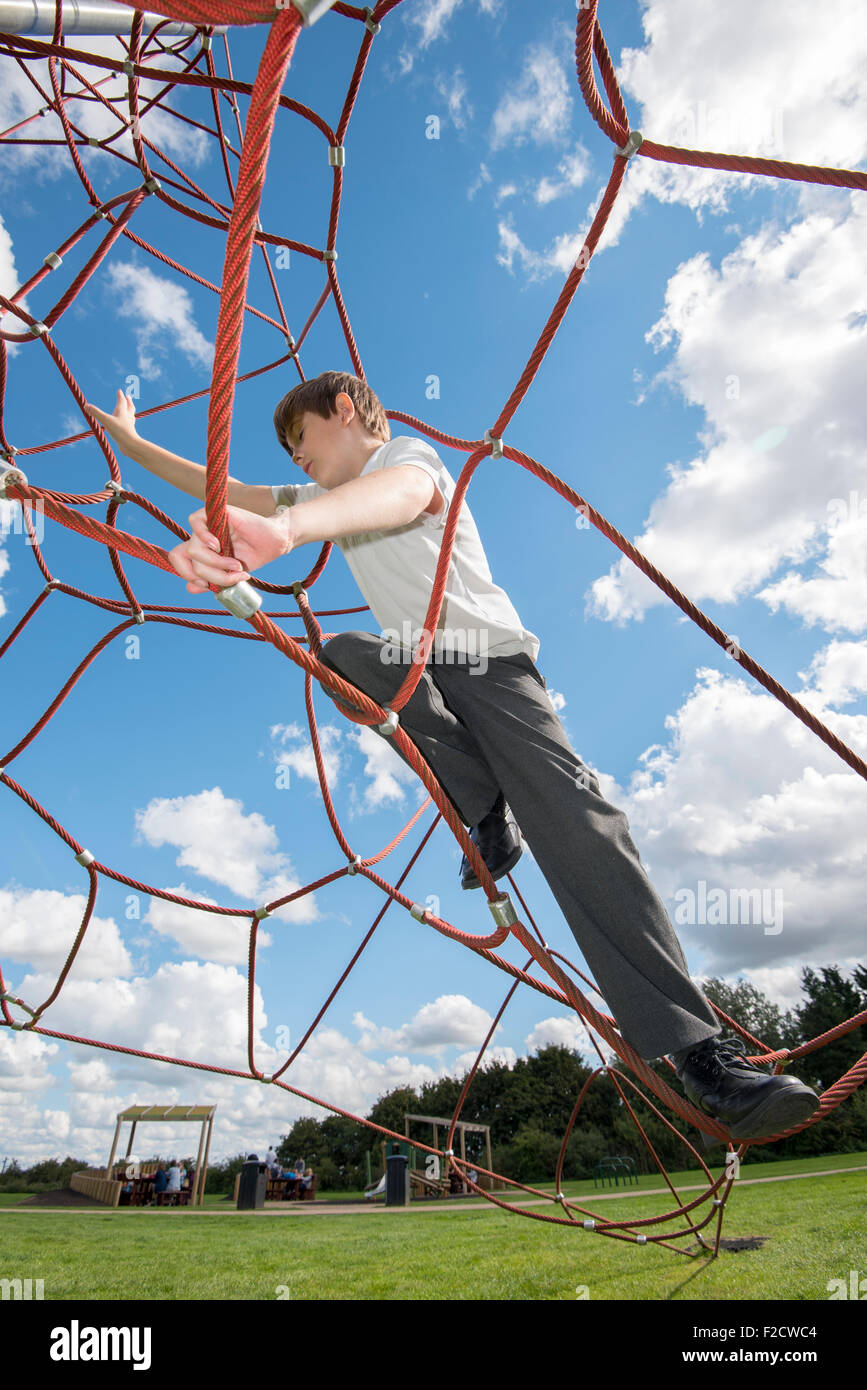 Boy climbing rope frame Stock Photo - Alamy