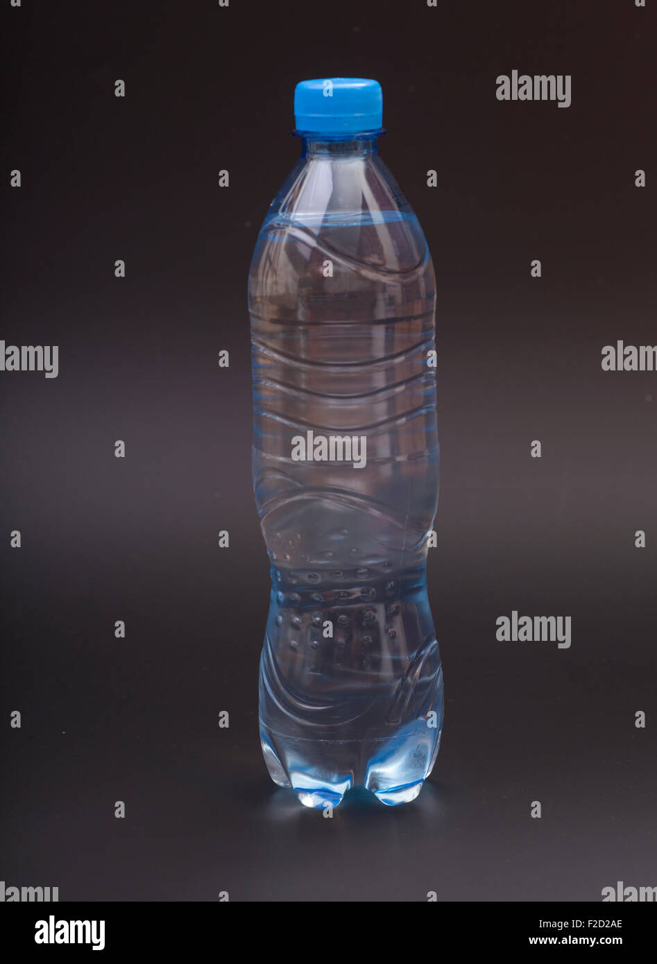 Small plastic water bottle on black background Stock Photo - Alamy