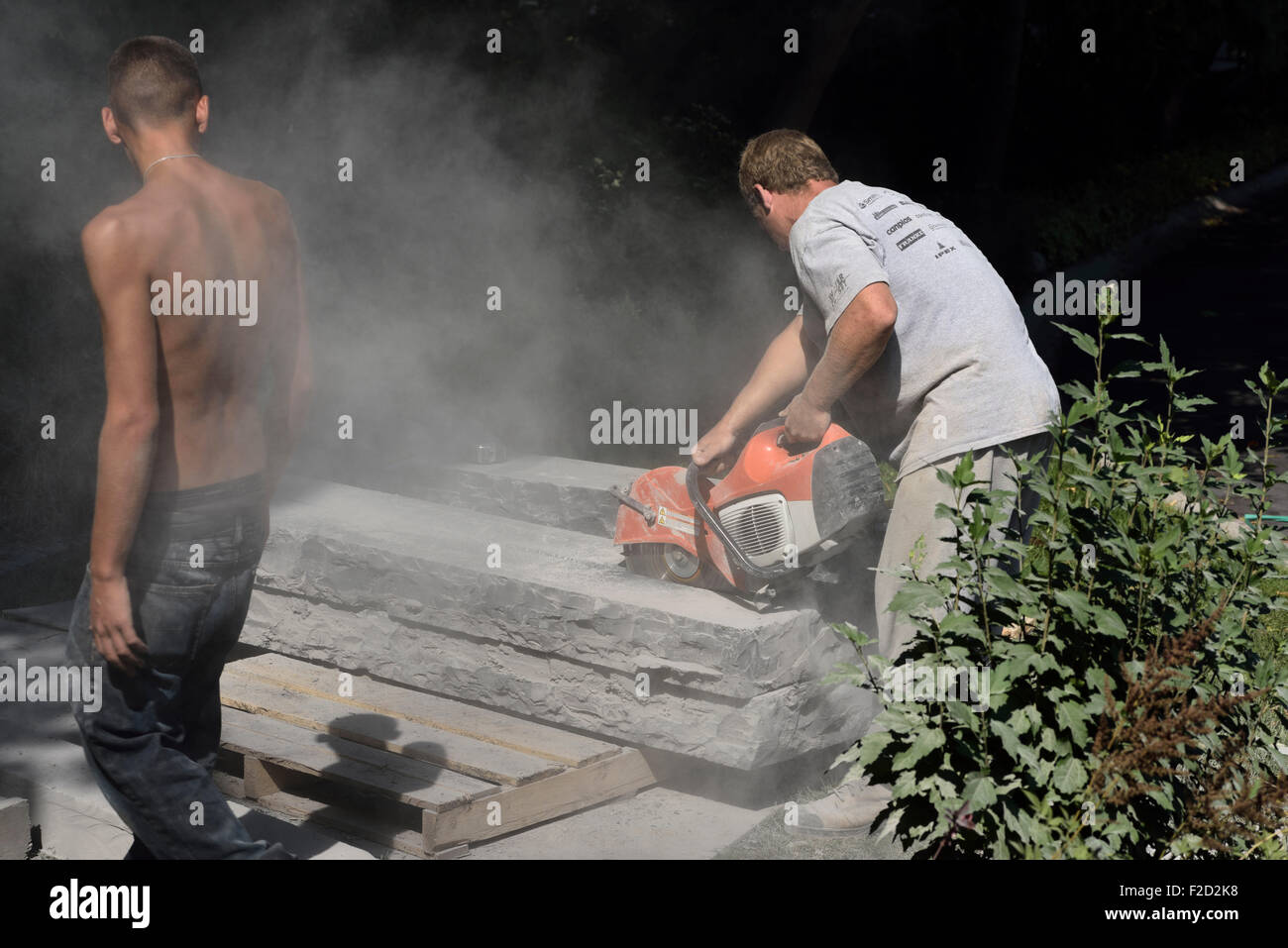 Construction workers making dust while cutting natural stone slabs ...