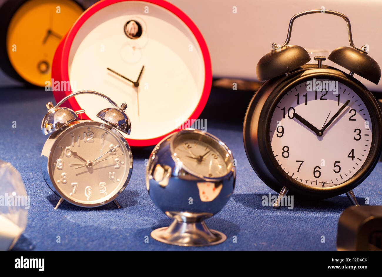 A lot of various Alarm clock on blue carpet Stock Photo - Alamy