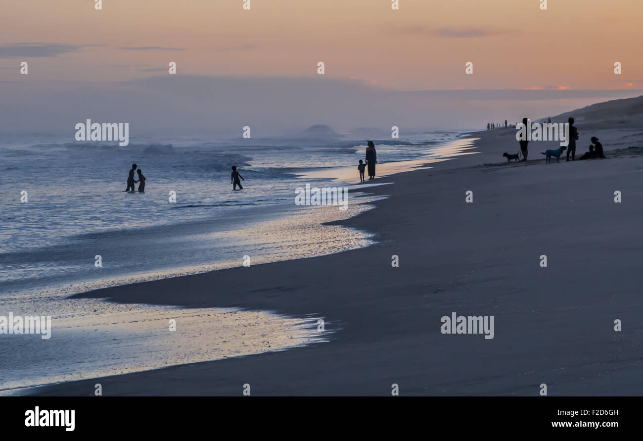 People relaxing on the beach at sunset Stock Photo - Alamy