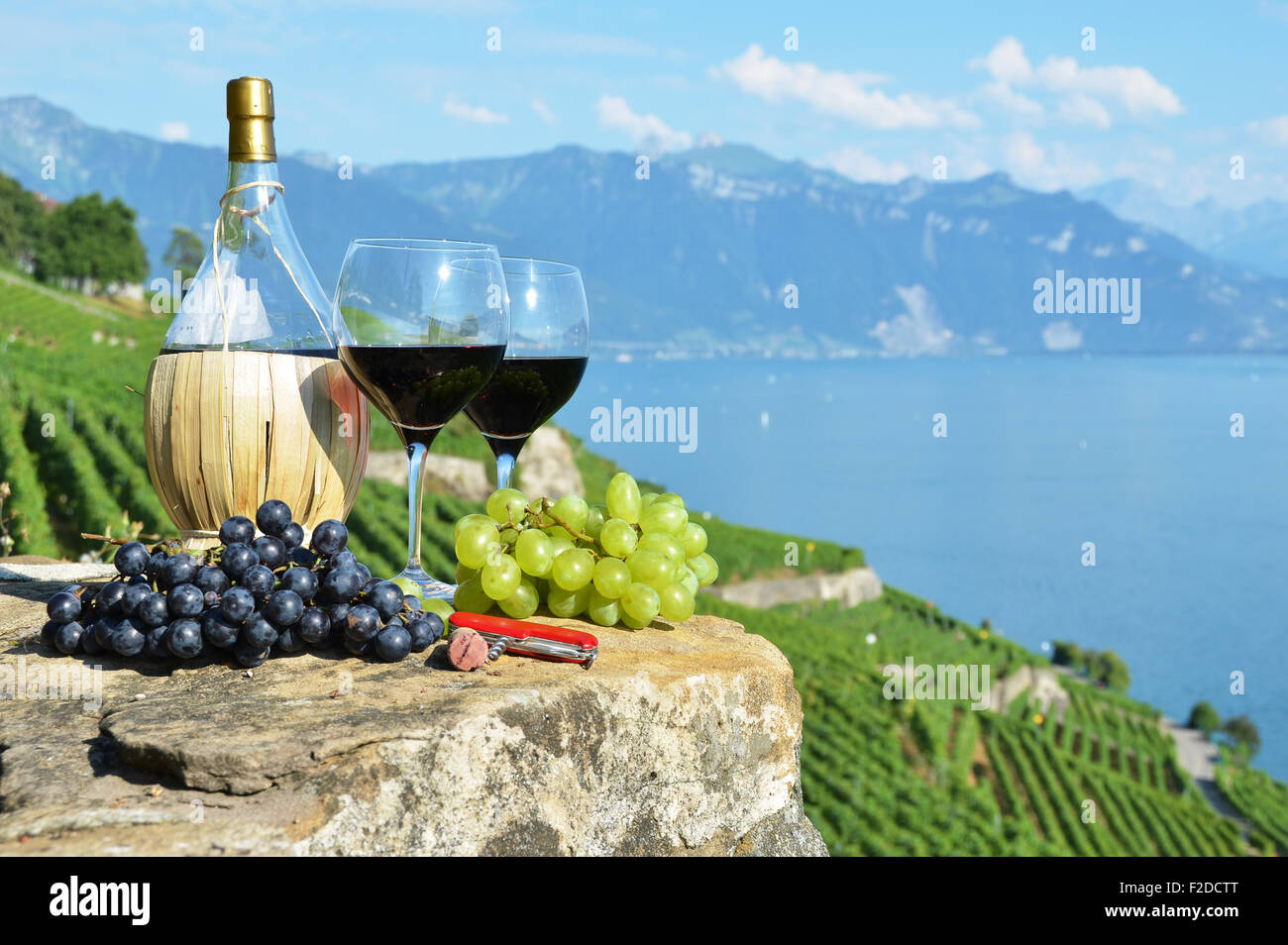 Red wine and grapes on the terrace of vineyard in Lavaux region ...