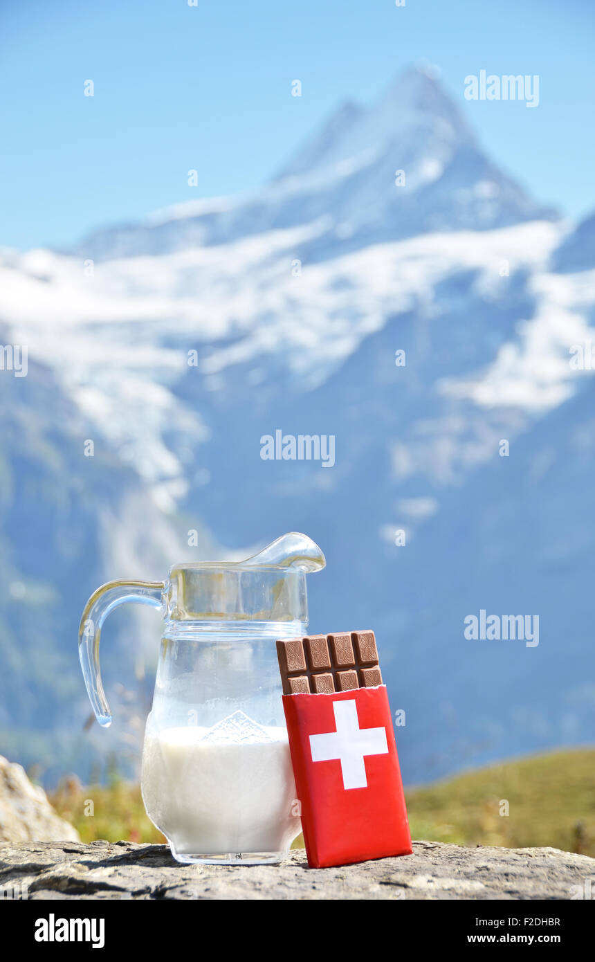 Swiss chocolate and jug of milk against mountain peak. Switzerland ...