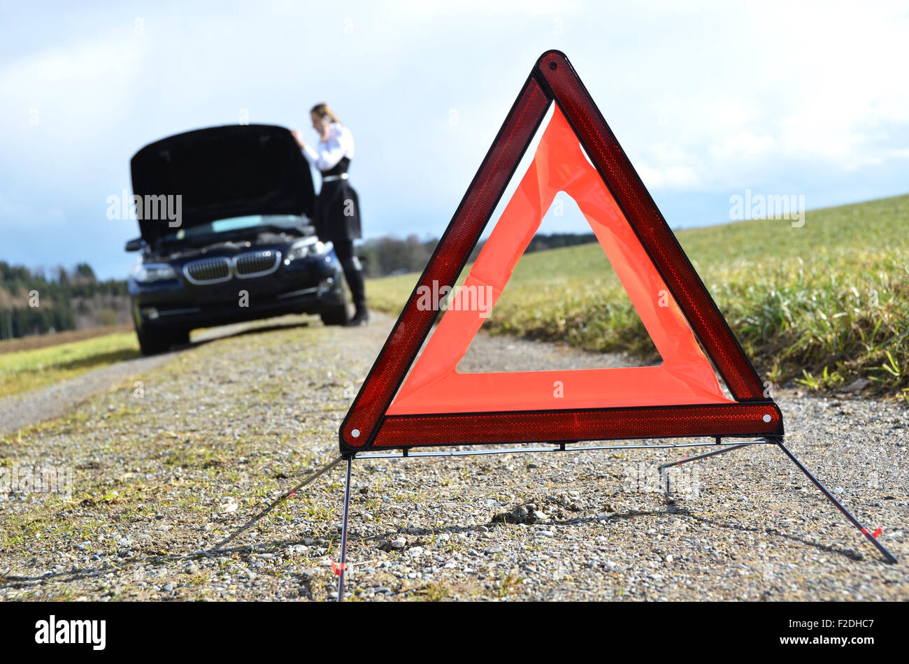 Broken car, girl and warning triangle Stock Photo - Alamy