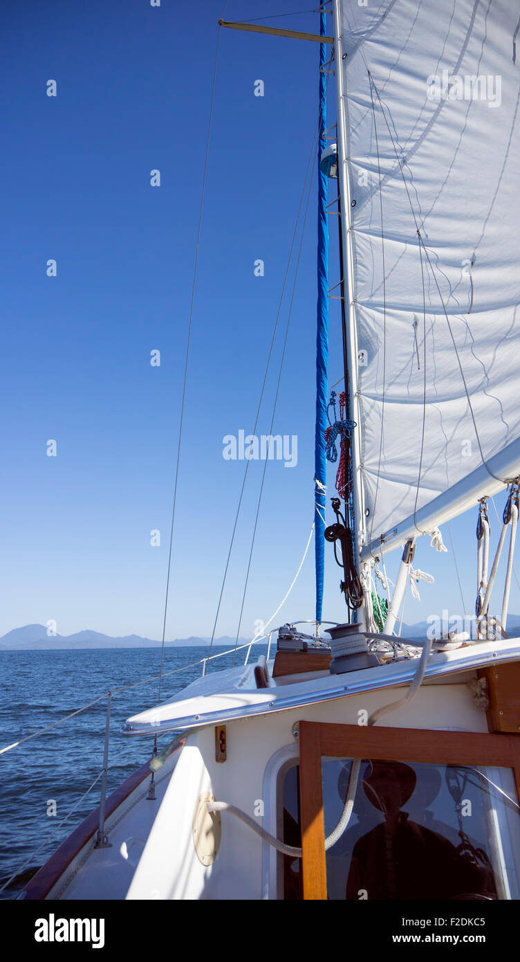 Sailboat with main sail up with the skipper reflected in the glass in ...