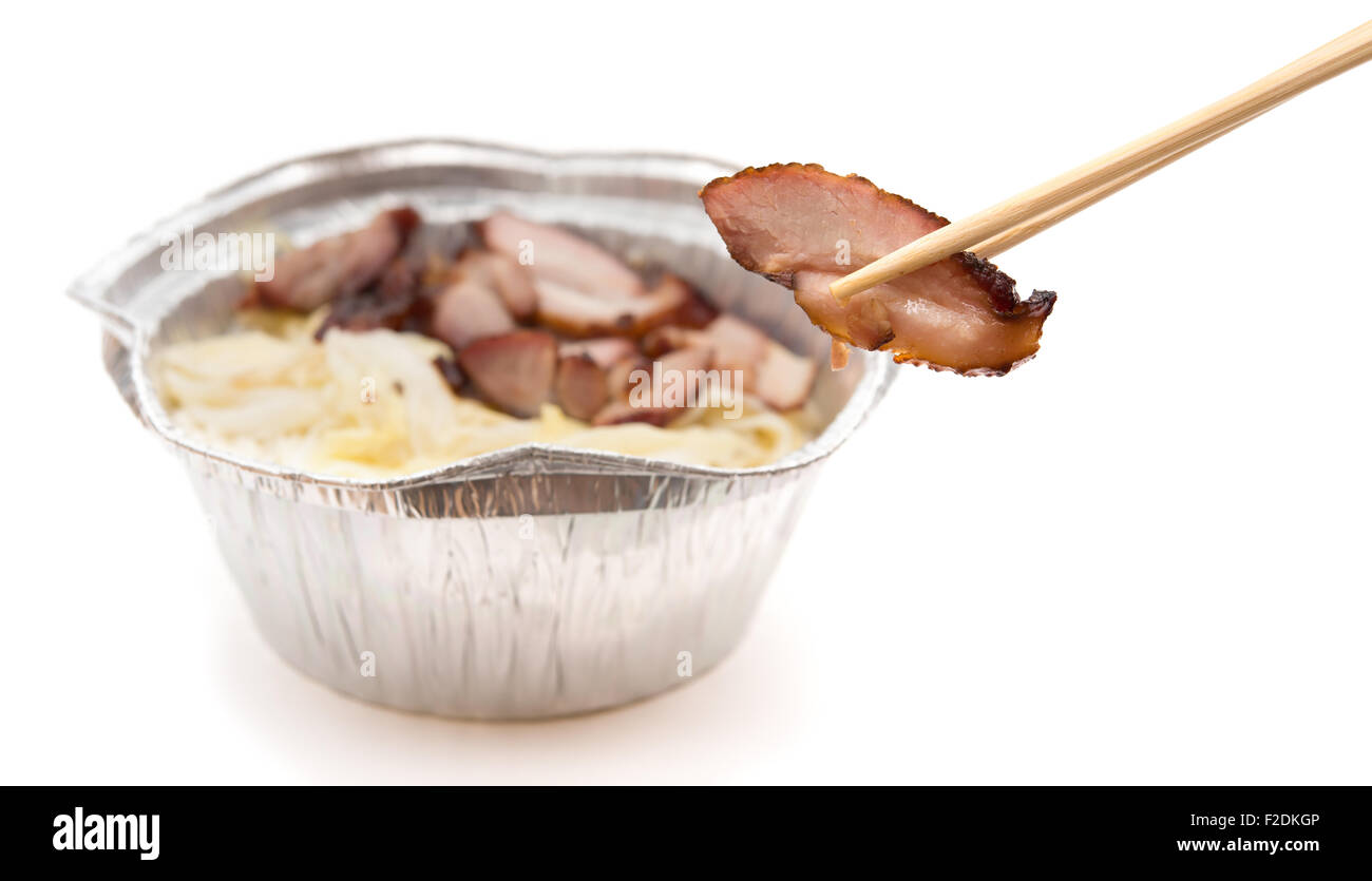 chopsticks catching a piece of barbeque pork with a fast food bowl at ...