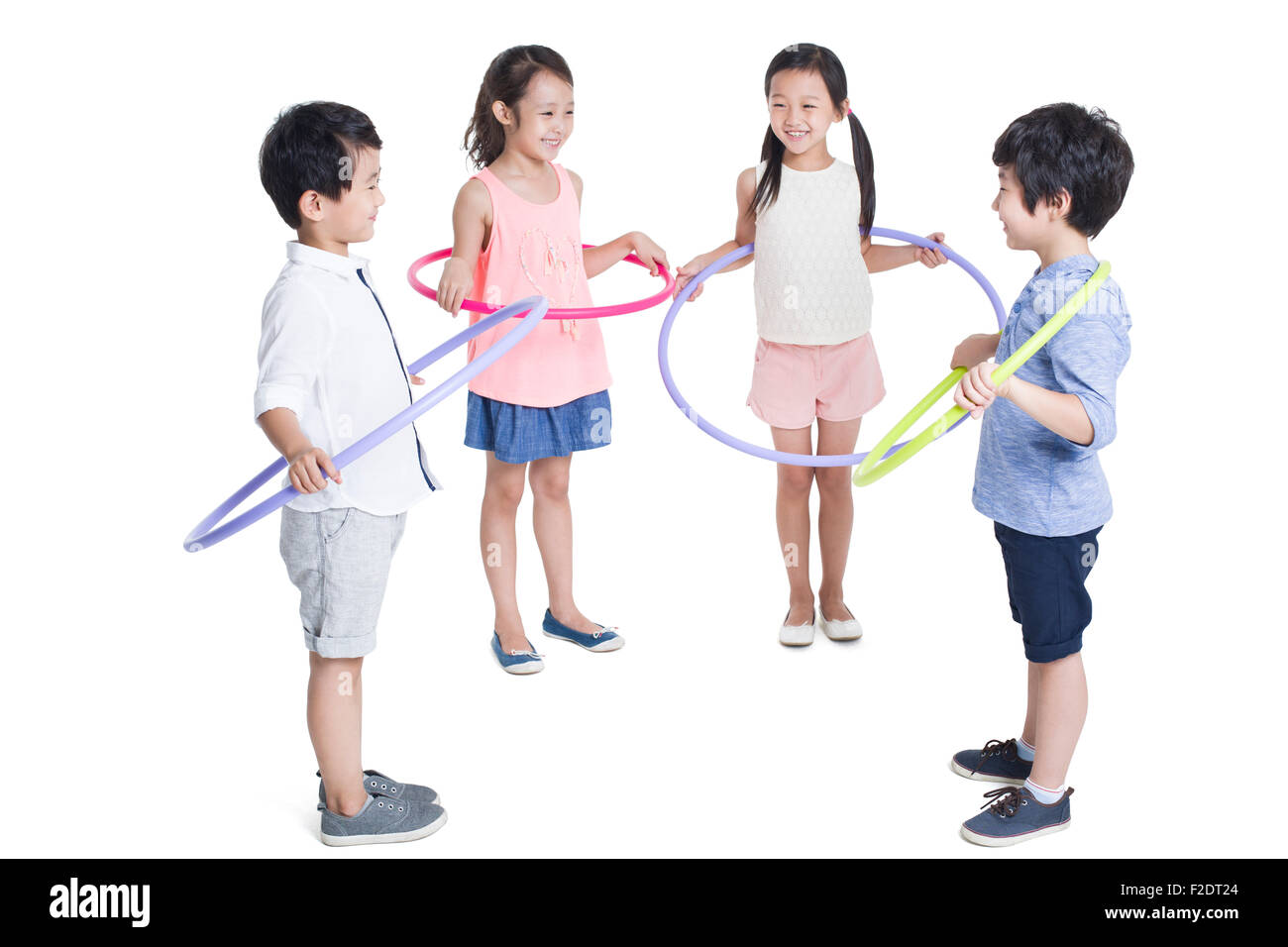 Happy children spinning plastic hoops Stock Photo - Alamy