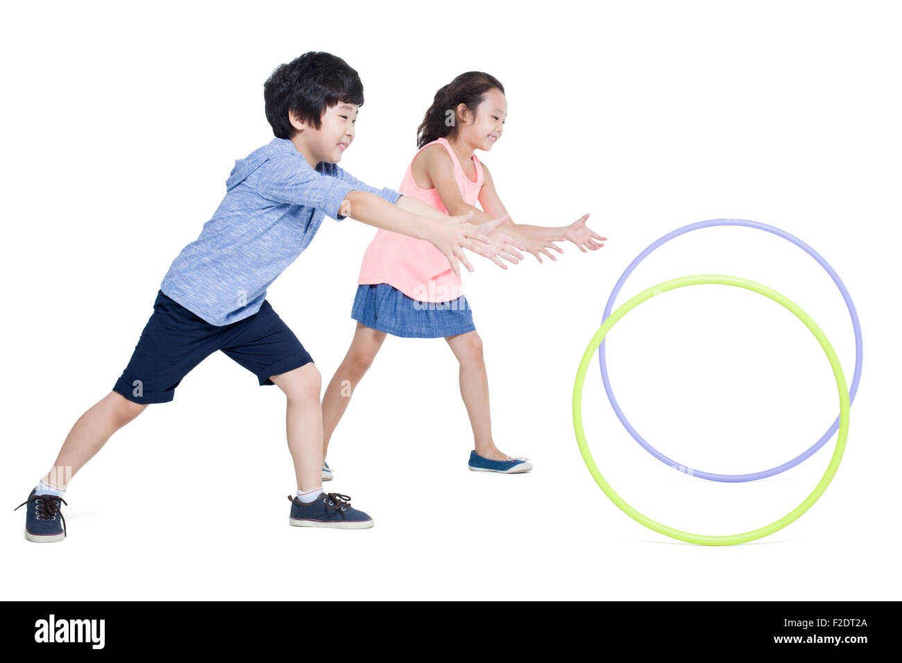 Happy children rolling plastic hoops Stock Photo - Alamy