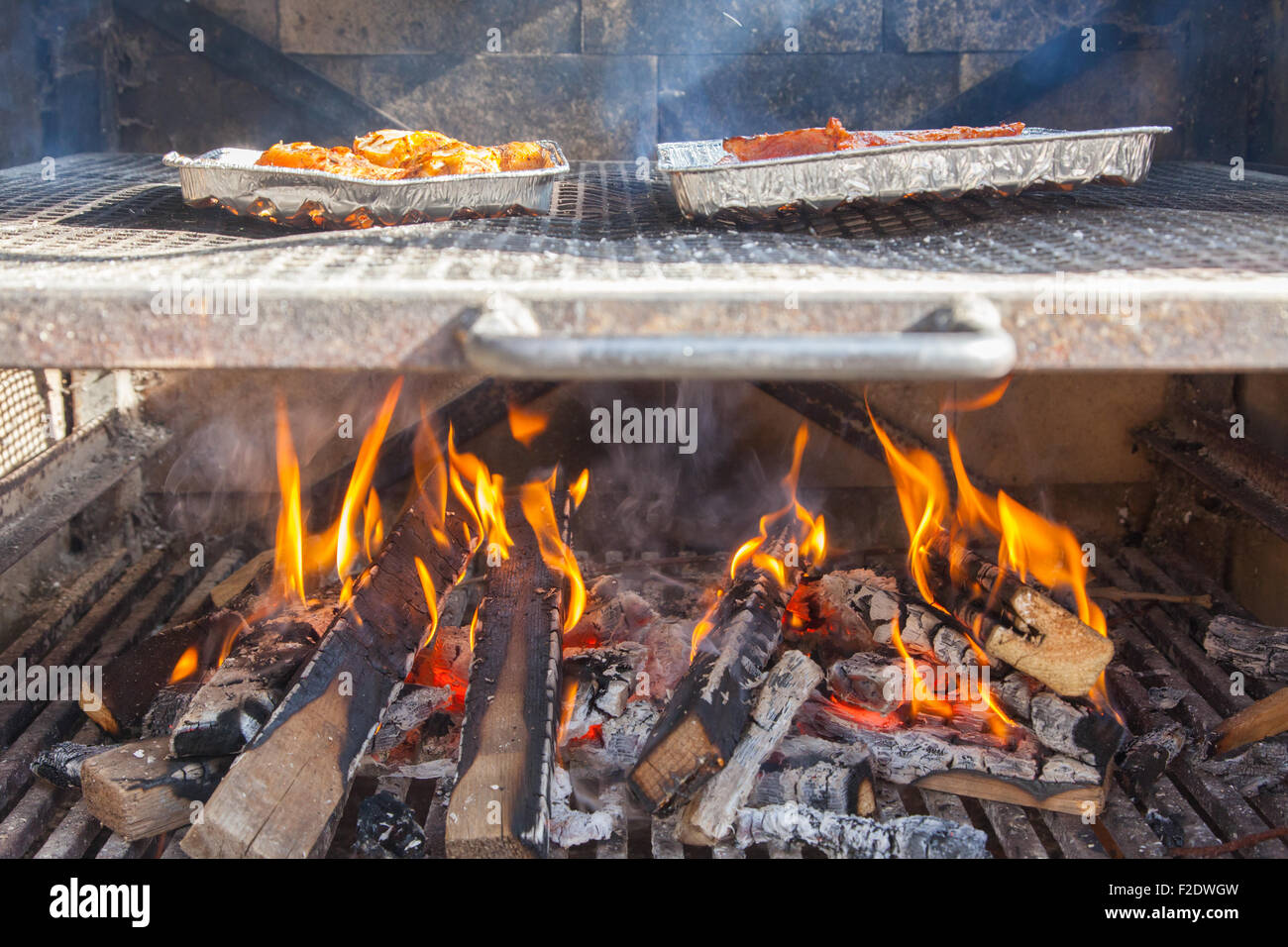 Meat getting ready on a large bbq Stock Photo - Alamy