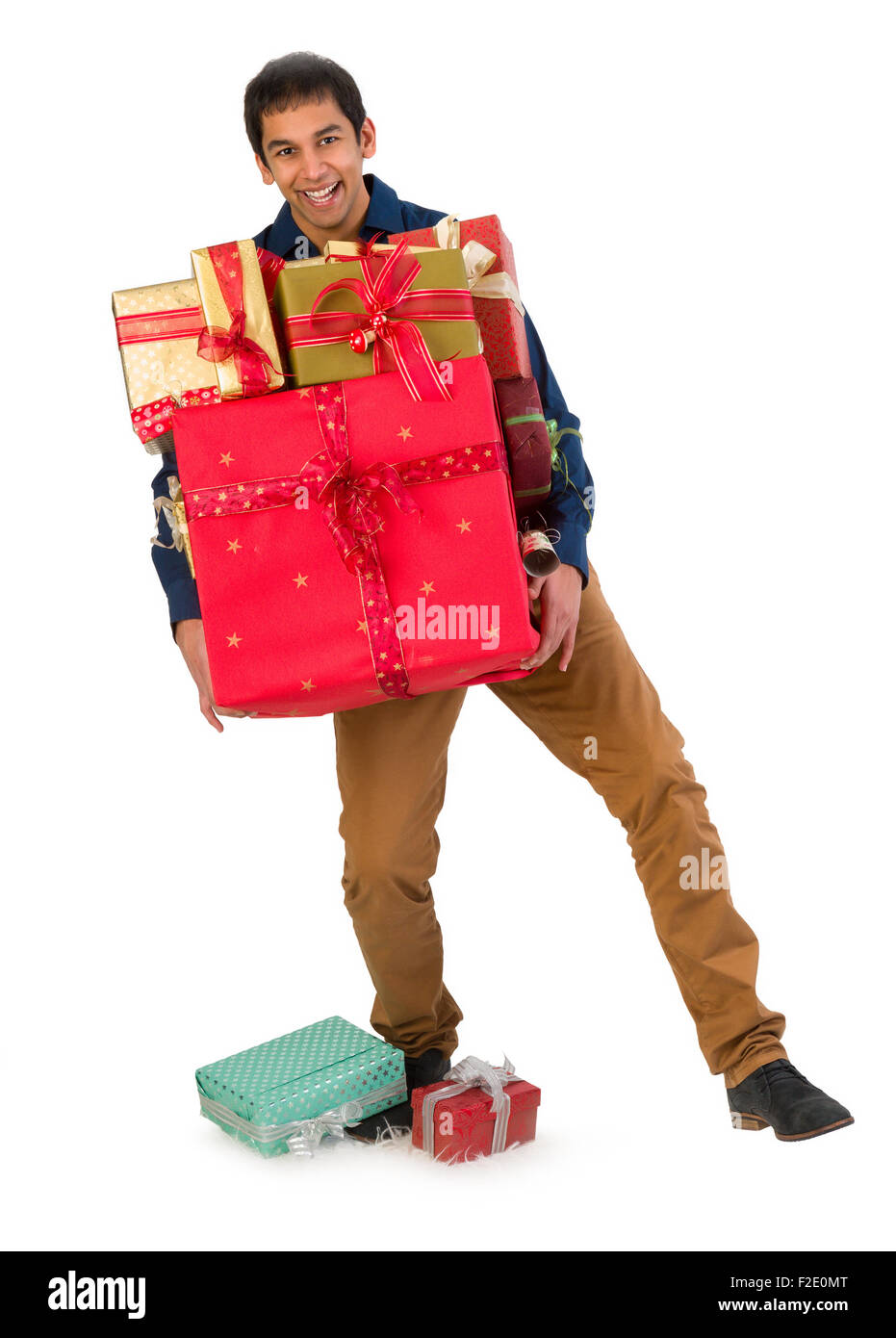 Happy young man holding too many Christmas presents Stock Photo - Alamy