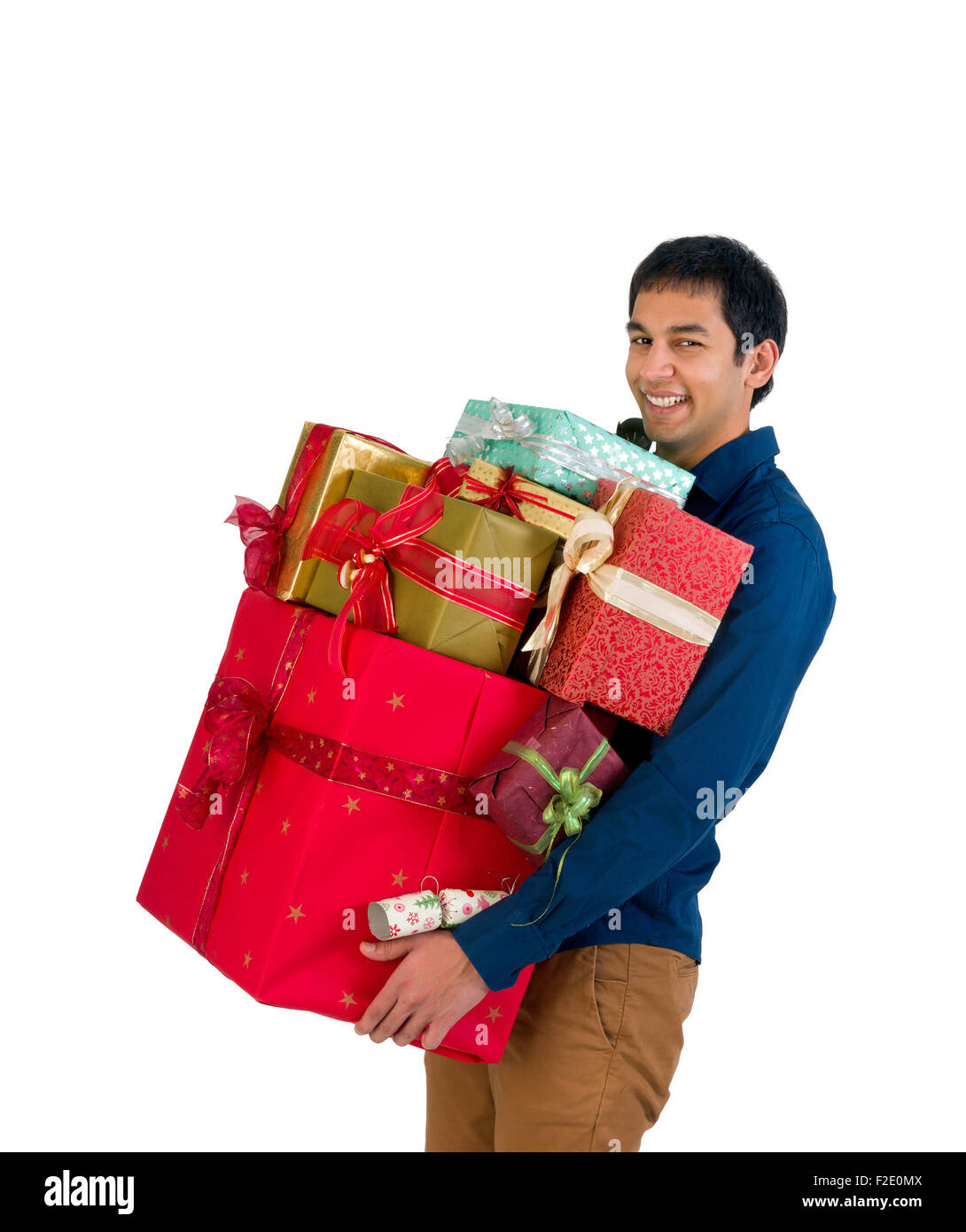 Happy young man holding too many Christmas presents Stock Photo - Alamy