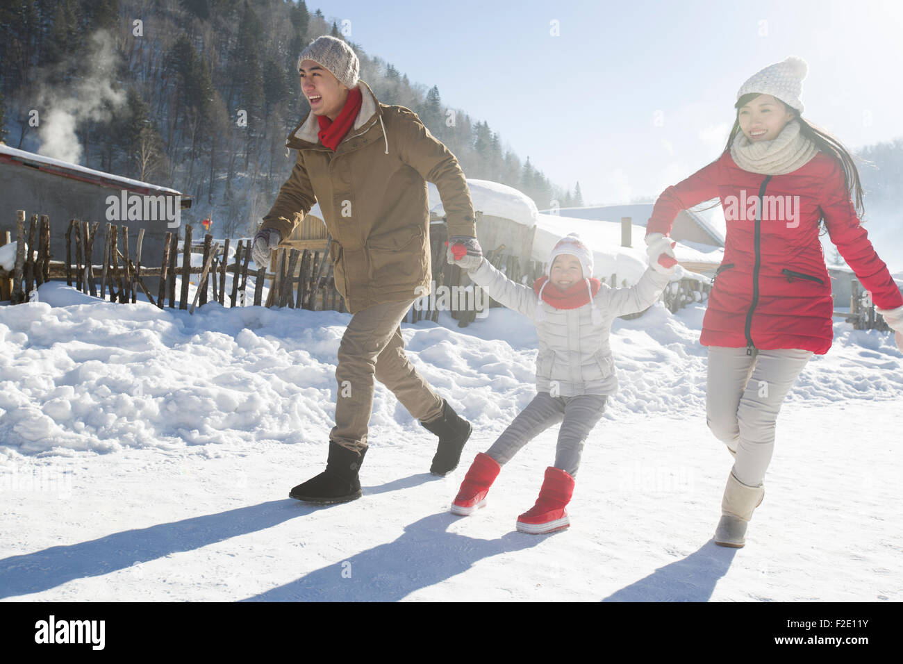 Happy family playing in the snow Stock Photo - Alamy