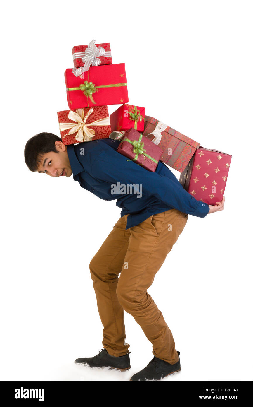 Happy young man holding too many Christmas presents Stock Photo - Alamy