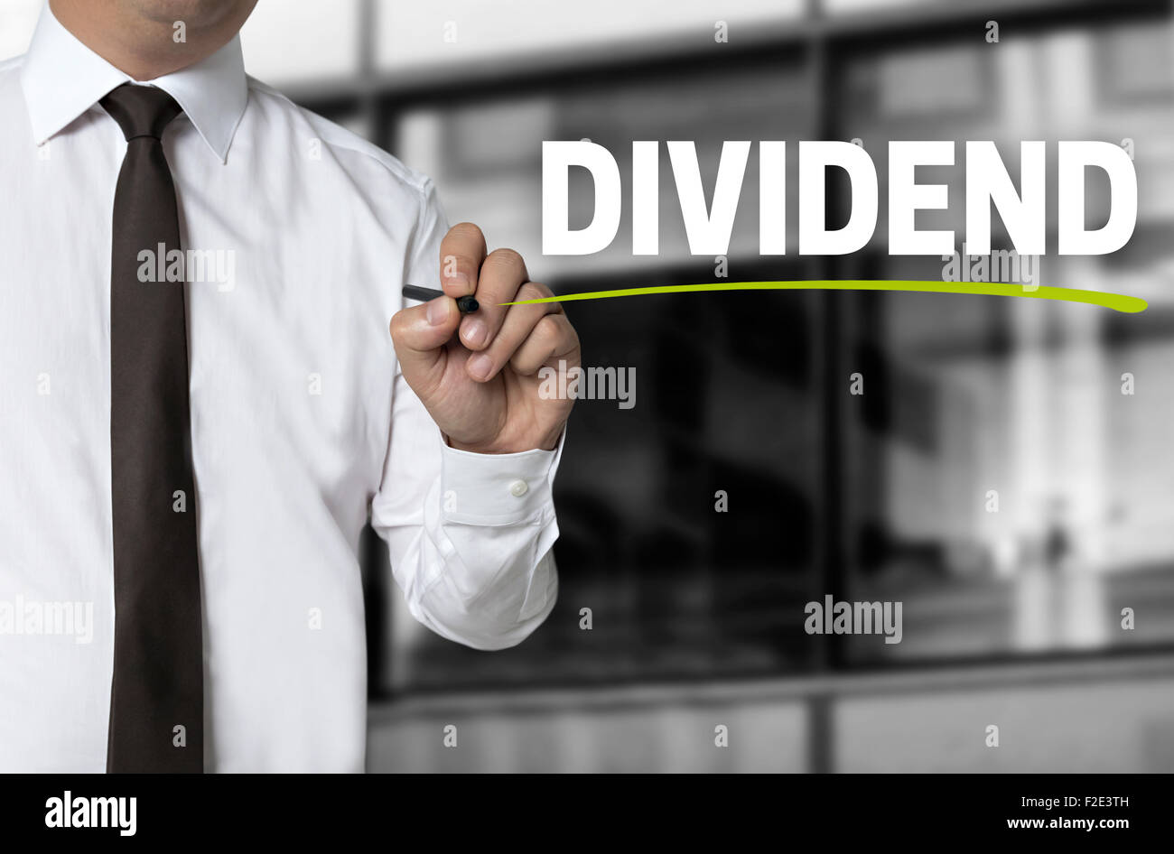 Dividend is written by businessman background concept Stock Photo - Alamy