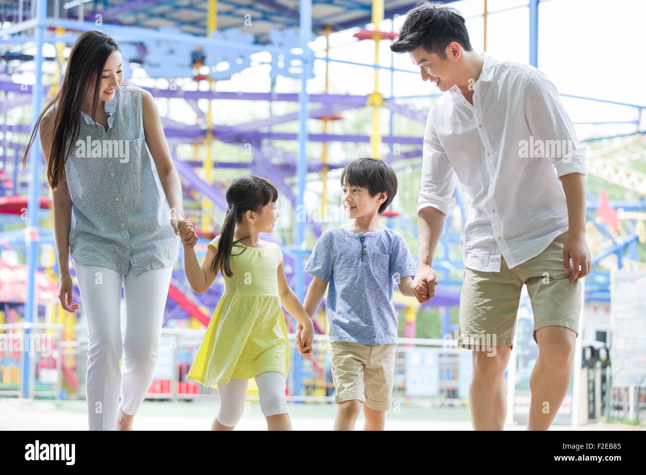 Happy young family playing in amusement park Stock Photo - Alamy