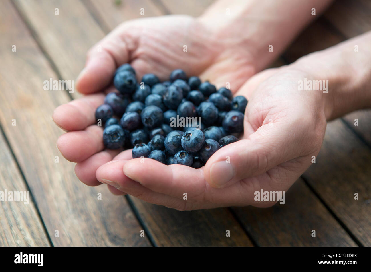 handful of blueberries with wooden table Stock Photo - Alamy