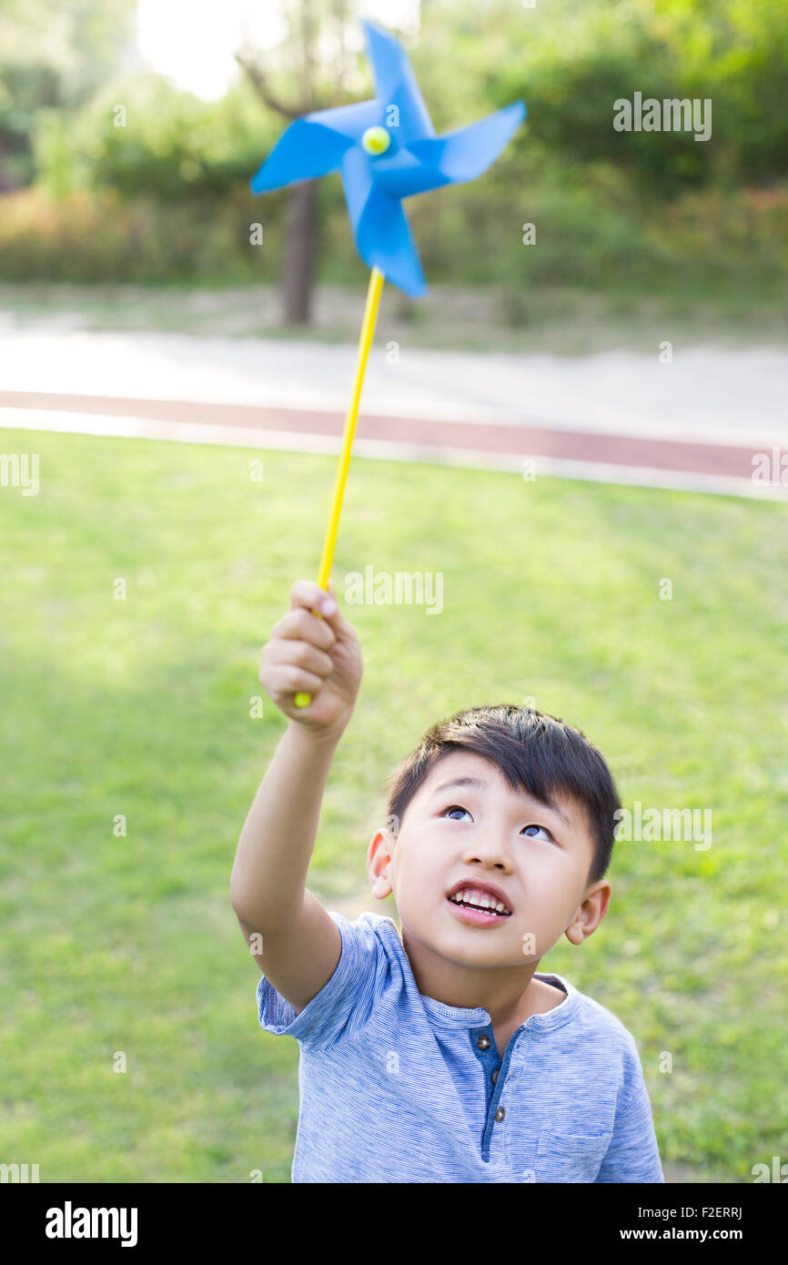 Happy boy playing with pinwheel Stock Photo - Alamy