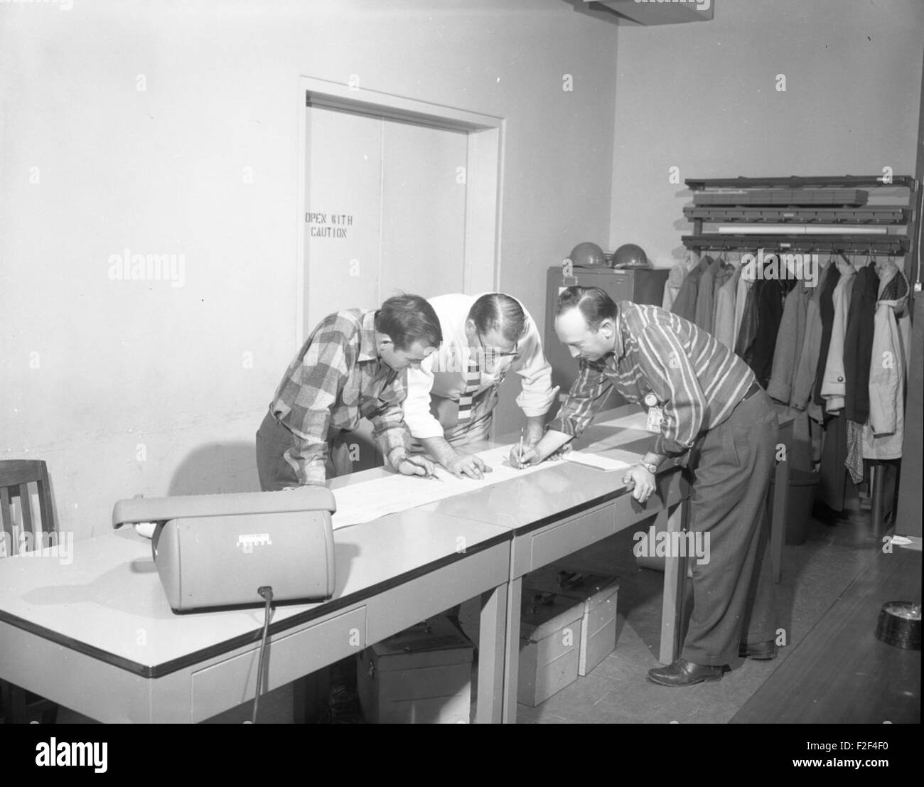 This photo from Edwards Rocket Base shows engineers working with ...