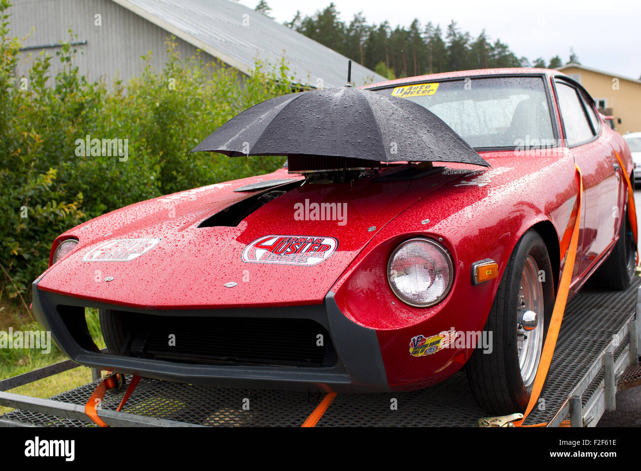 Drag racing Datsun standing in the rain with an umbrella over the ...