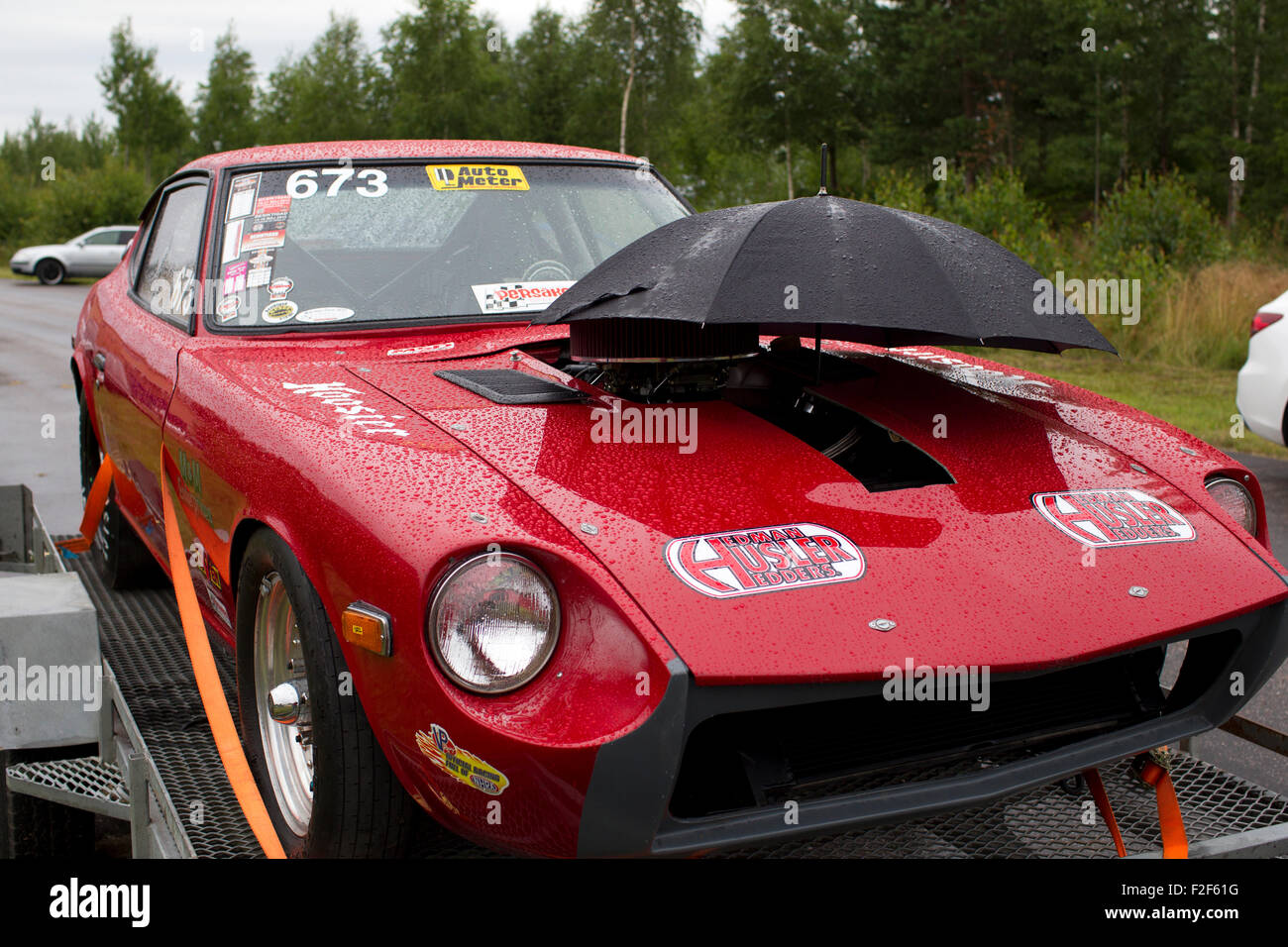 Drag racing Datsun standing in the rain with an umbrella over the ...
