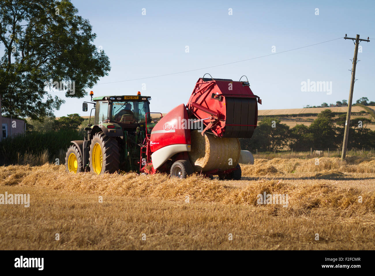 Tractor with baling machine working in a harvested wheat field Stock ...