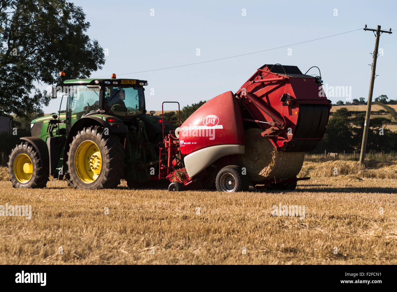 Tractor with baling machine working in a harvested wheat field Stock ...