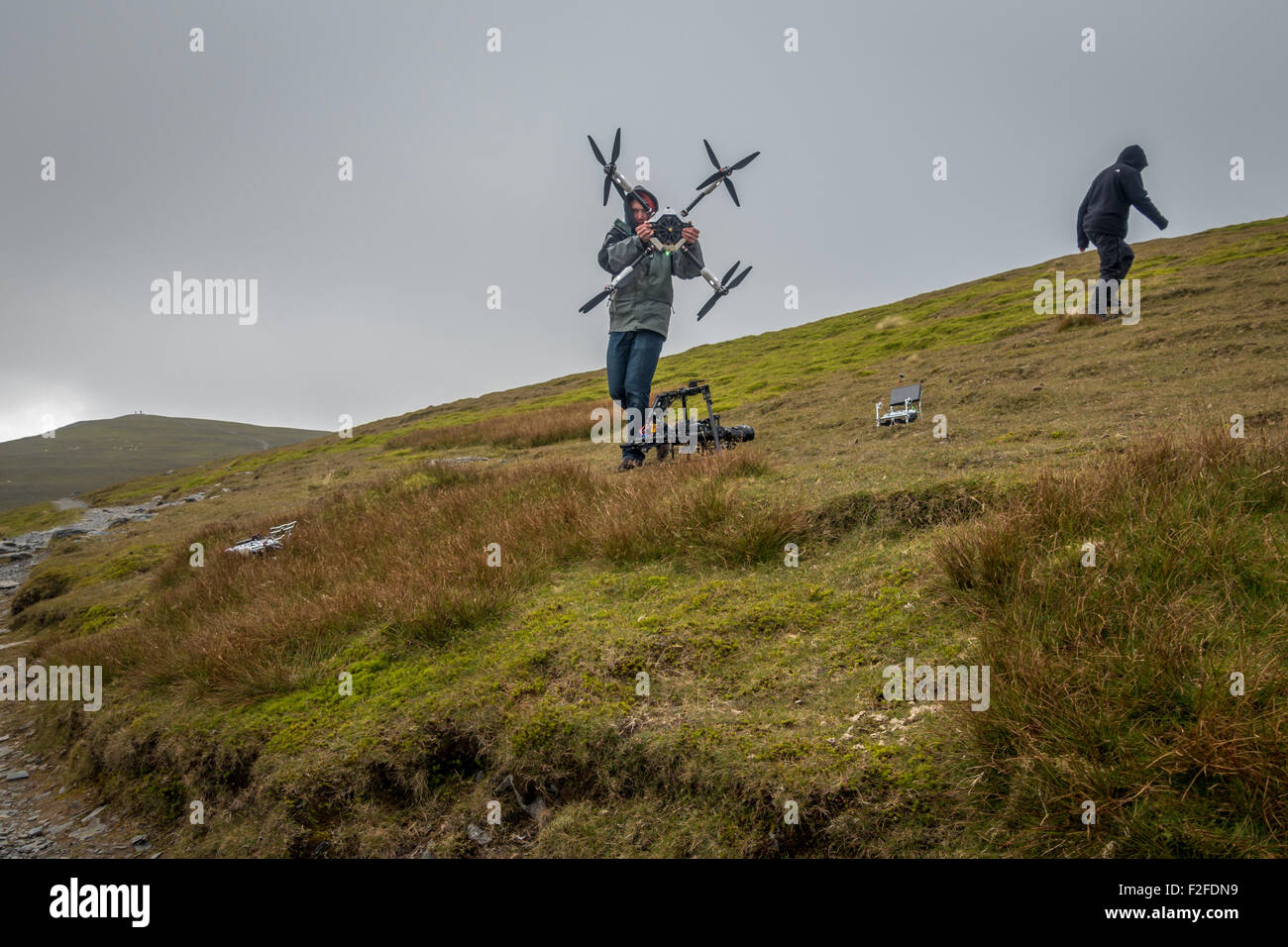 Film crew preparing a large expensive filming drone on the top of a ...