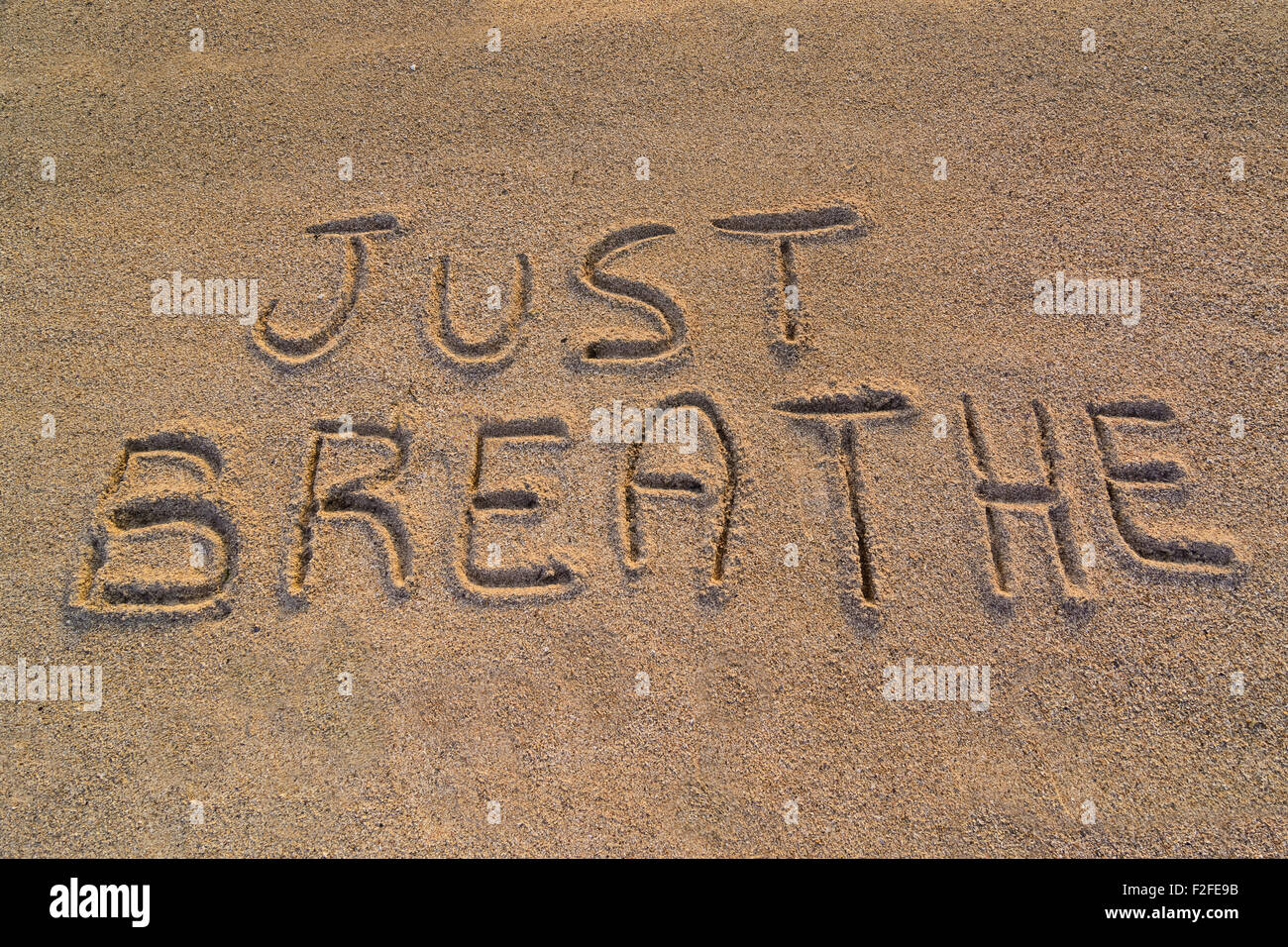 In the picture the words on the sand "Just breathe Stock Photo - Alamy