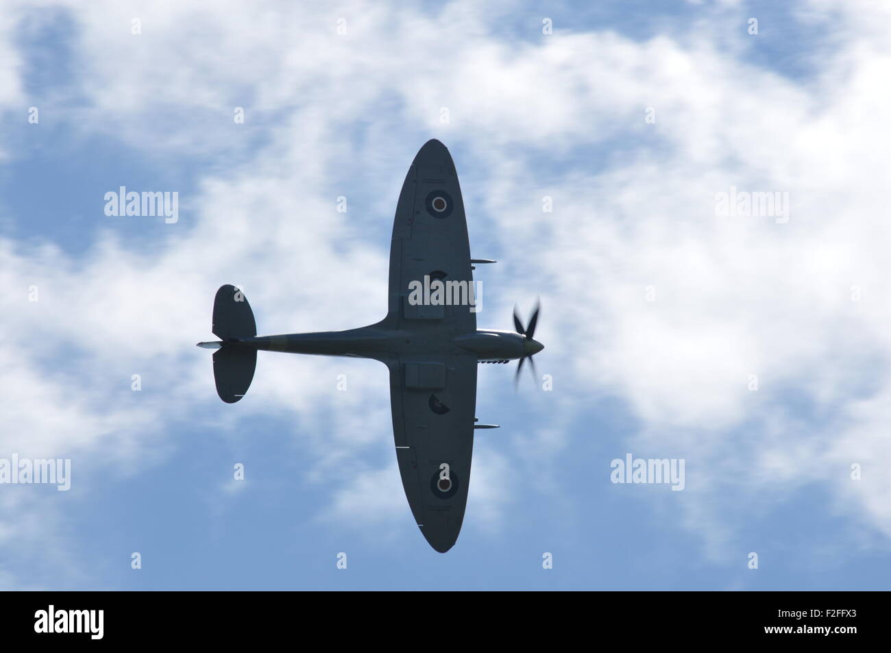 Supermarine Spitfire flying blue/cloudy sky underside view Stock Photo ...