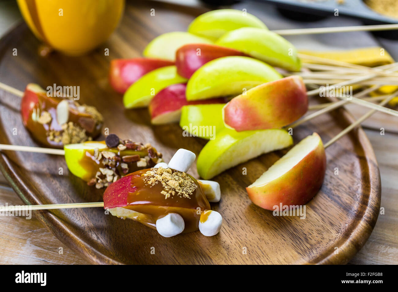 Apple slices dipped in caramel and covered with different toppings ...