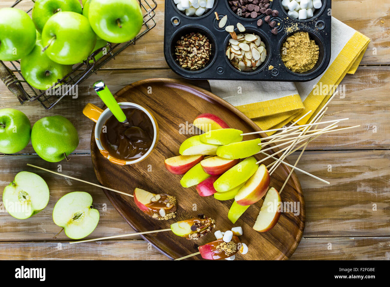 Apple slices dipped in caramel and covered with different toppings ...