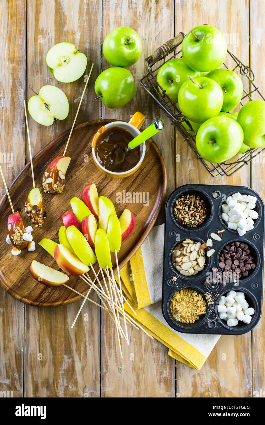 Apple slices dipped in caramel and covered with different toppings ...