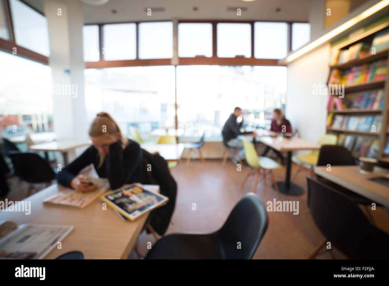 Out of focus shot of people reading in a library Stock Photo - Alamy