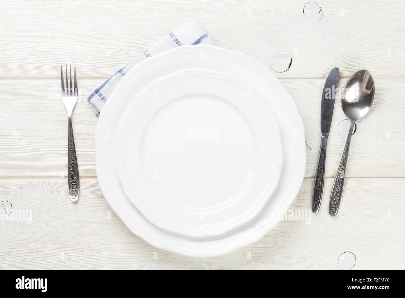 Empty plate and silverware over wooden table background. View from ...