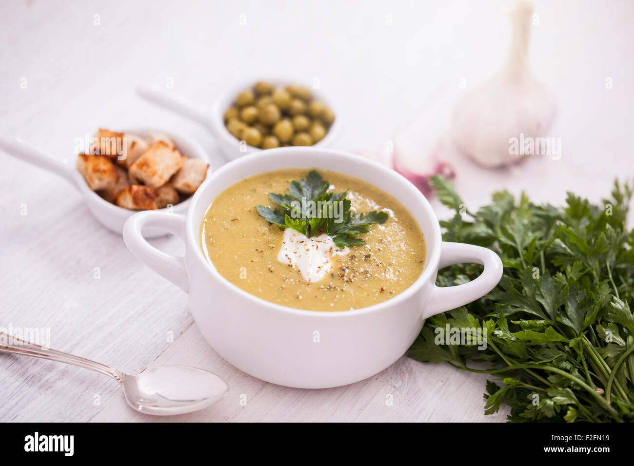 A delicious pea cream with aromatic spices on a wooden table. Studo ...