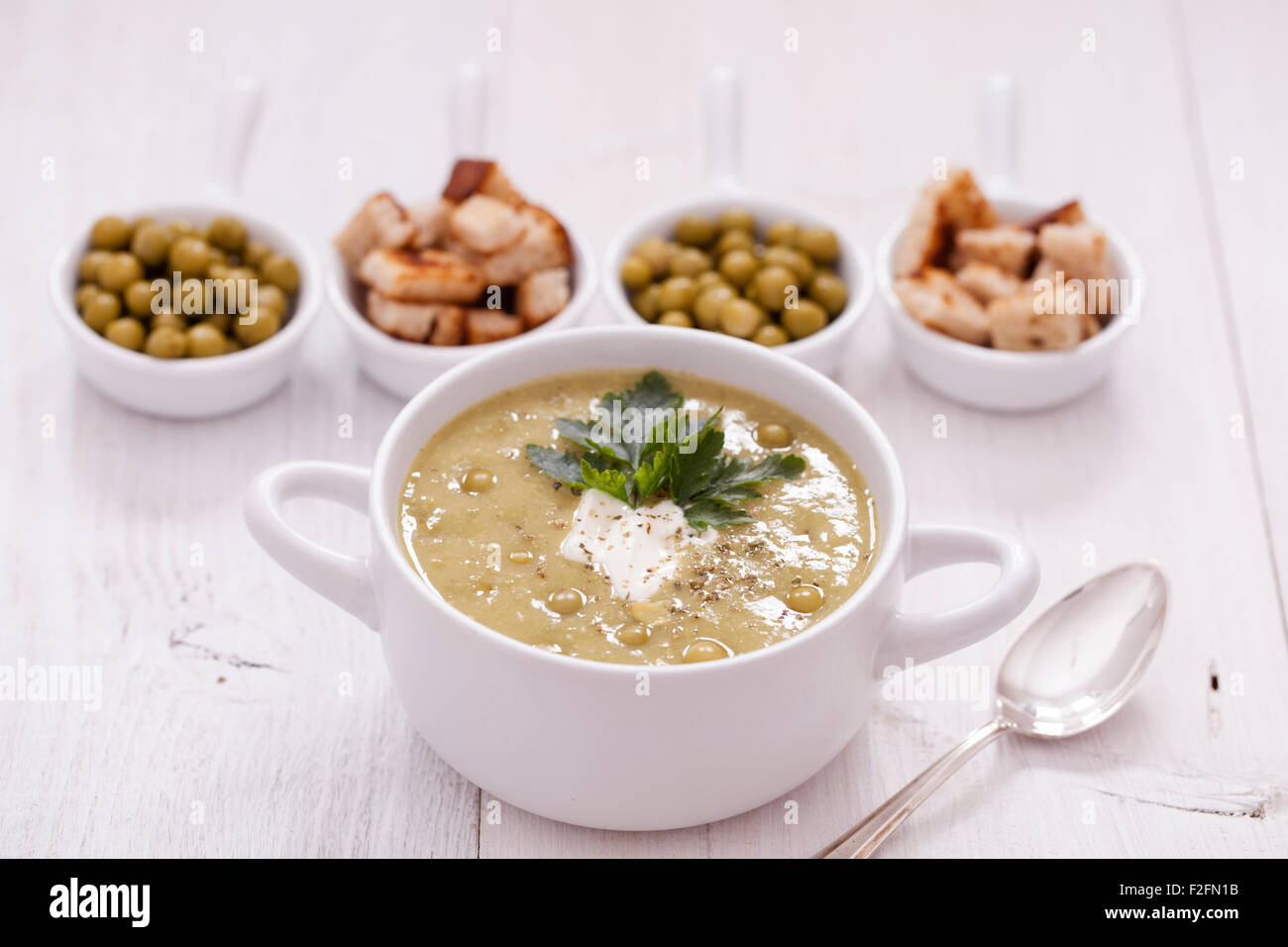 A delicious pea cream with aromatic spices on a wooden table. Studo ...