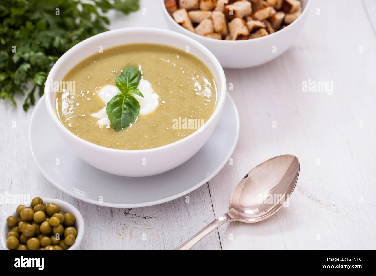 A delicious pea cream with aromatic spices on a wooden table. Studo ...