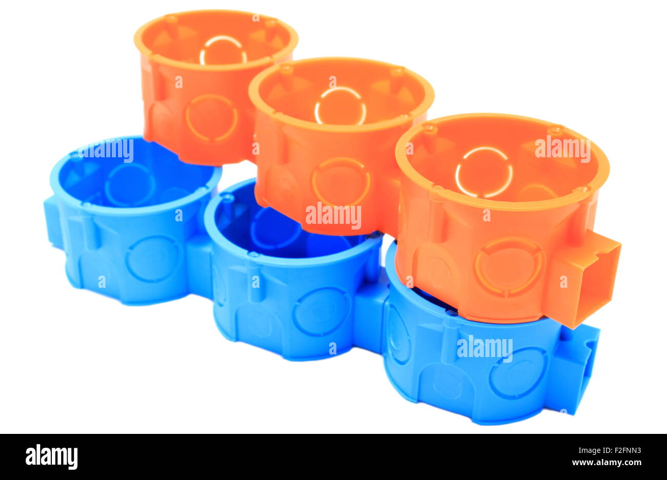 Stack of orange and blue plastic electrical boxes on white background ...