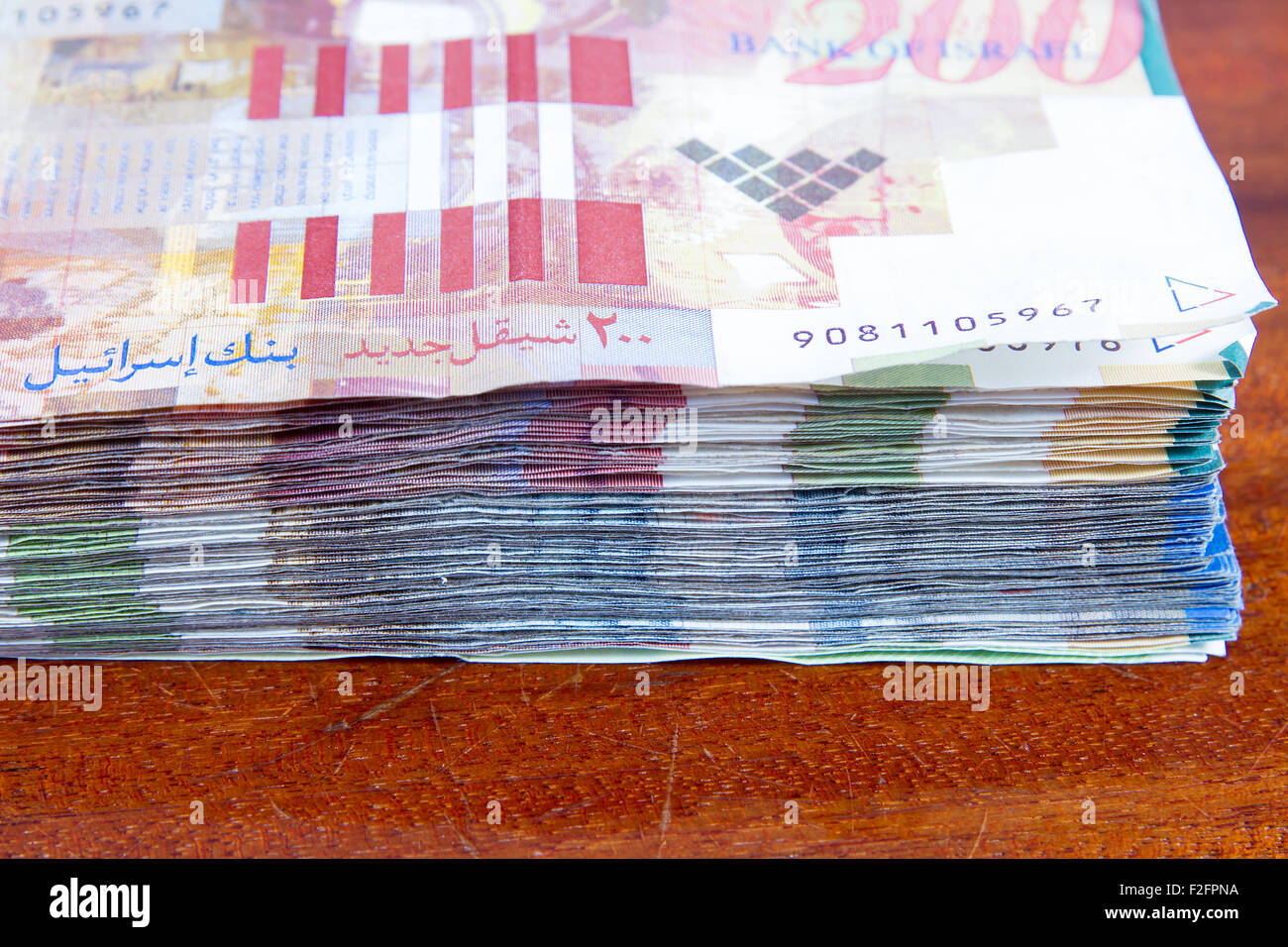 Two hundred and one hundred shekel bank notes against wood background ...