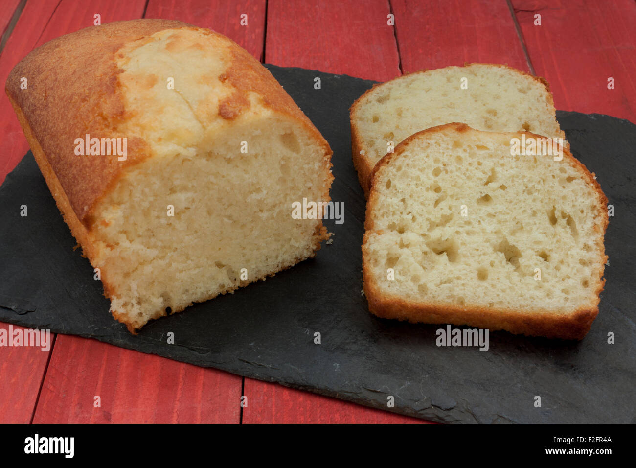 a frontal view of sponge cake with two slices over a slate Stock Photo ...