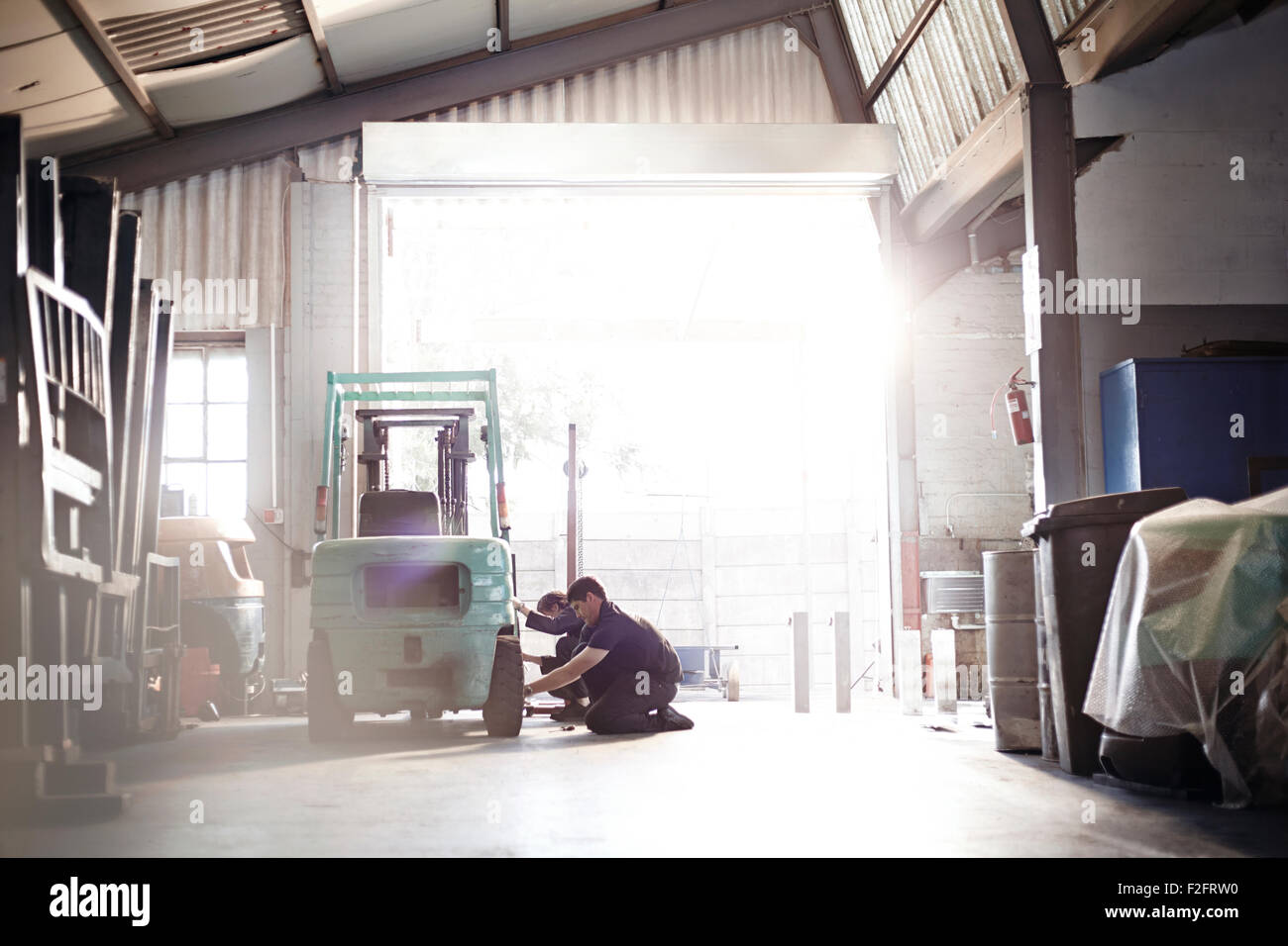 Mechanics repairing forklift in auto repair shop Stock Photo - Alamy