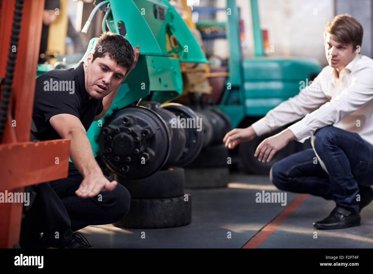 Mechanic and customer talking in auto repair shop Stock Photo - Alamy