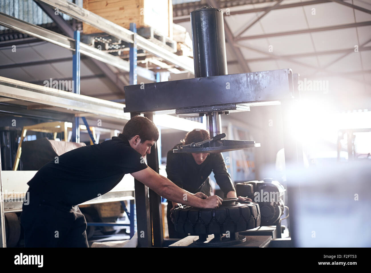 Mechanics fixing tire in auto repair shop Stock Photo - Alamy