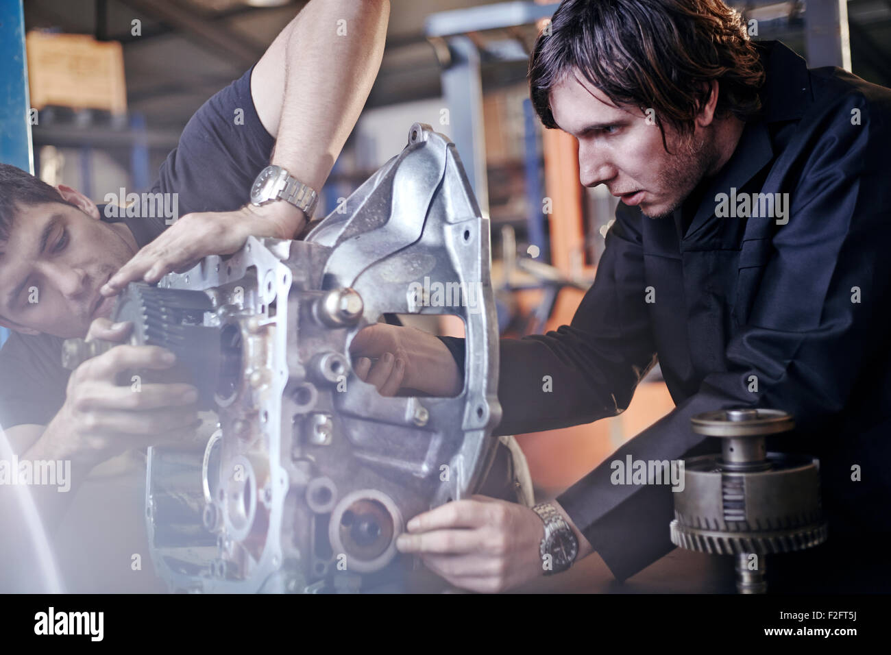 Mechanics fixing part in auto repair shop Stock Photo - Alamy