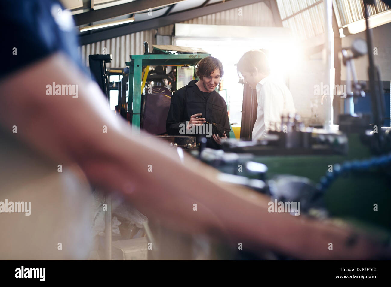 Mechanic and customer talking in auto repair shop Stock Photo - Alamy