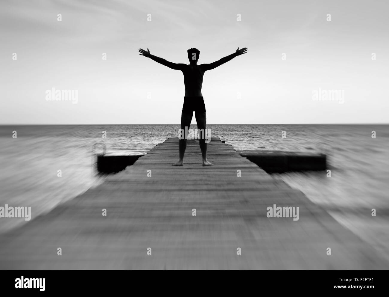 Silhouette of free peaceful man on sea pier Stock Photo - Alamy
