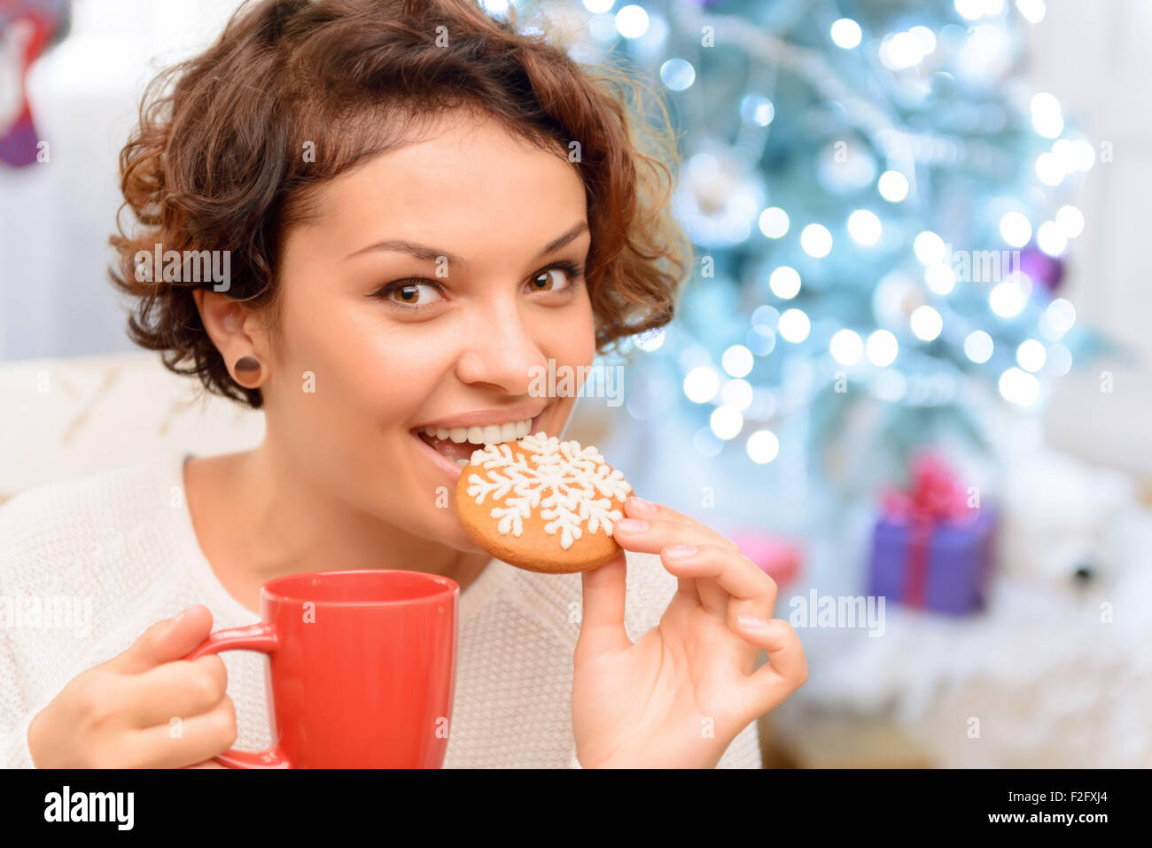 Nice girl eating cookie Stock Photo - Alamy