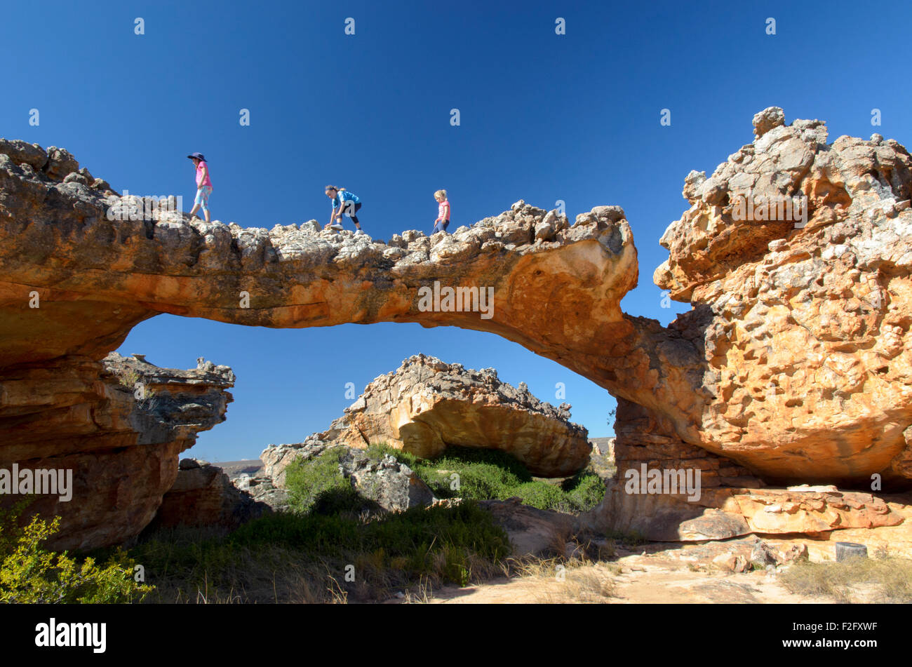 Hikers on a rock arch in the Cederberg mountains of South Africa Stock ...