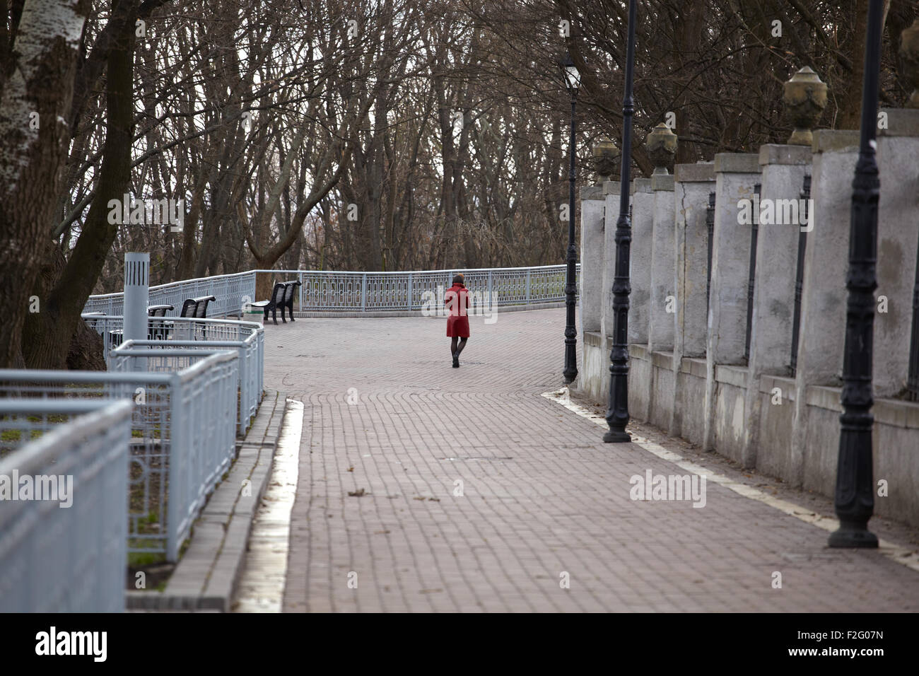 Woman in red walking in the street Stock Photo - Alamy