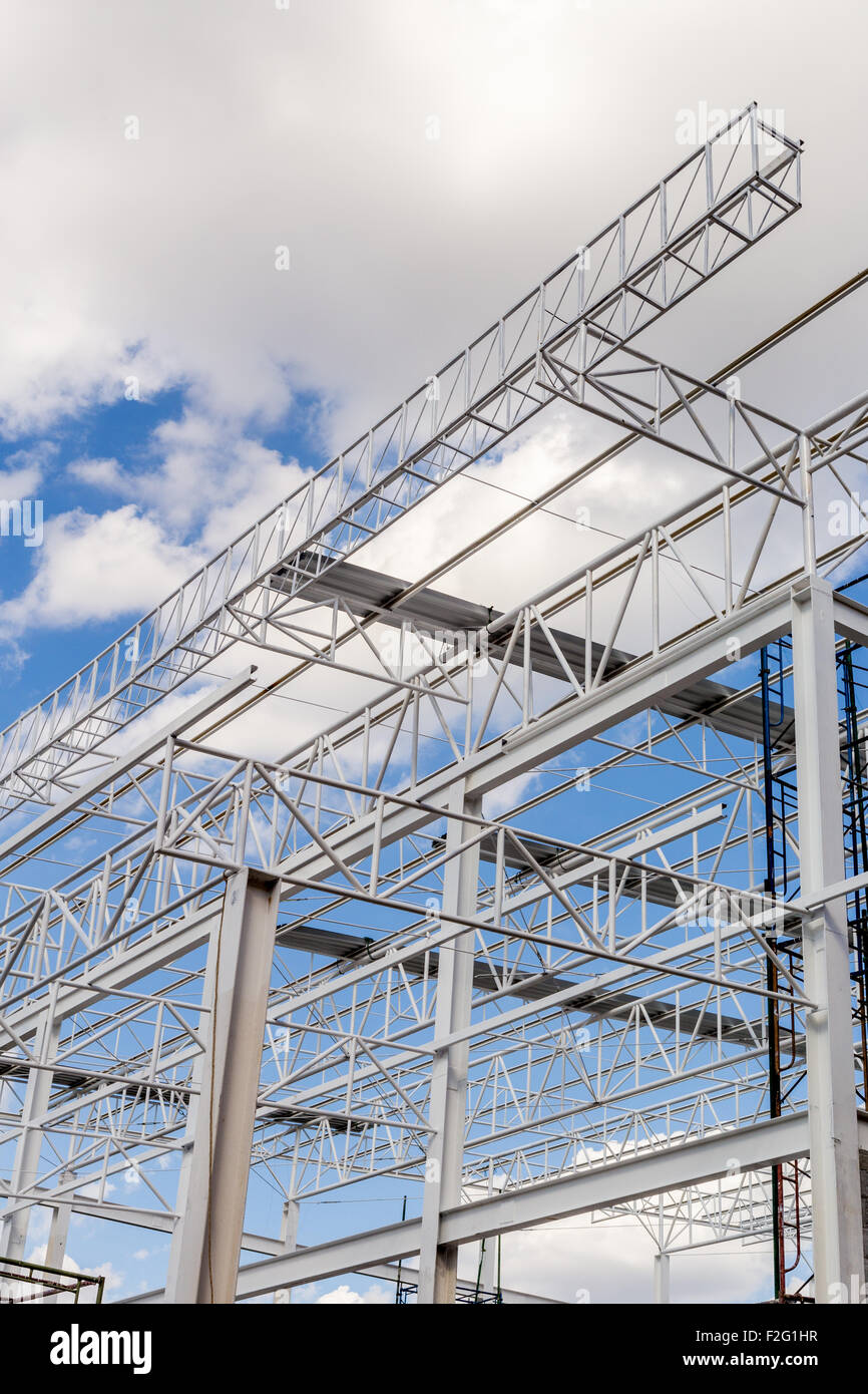 Construction of steel frame of big building with blue sky background ...